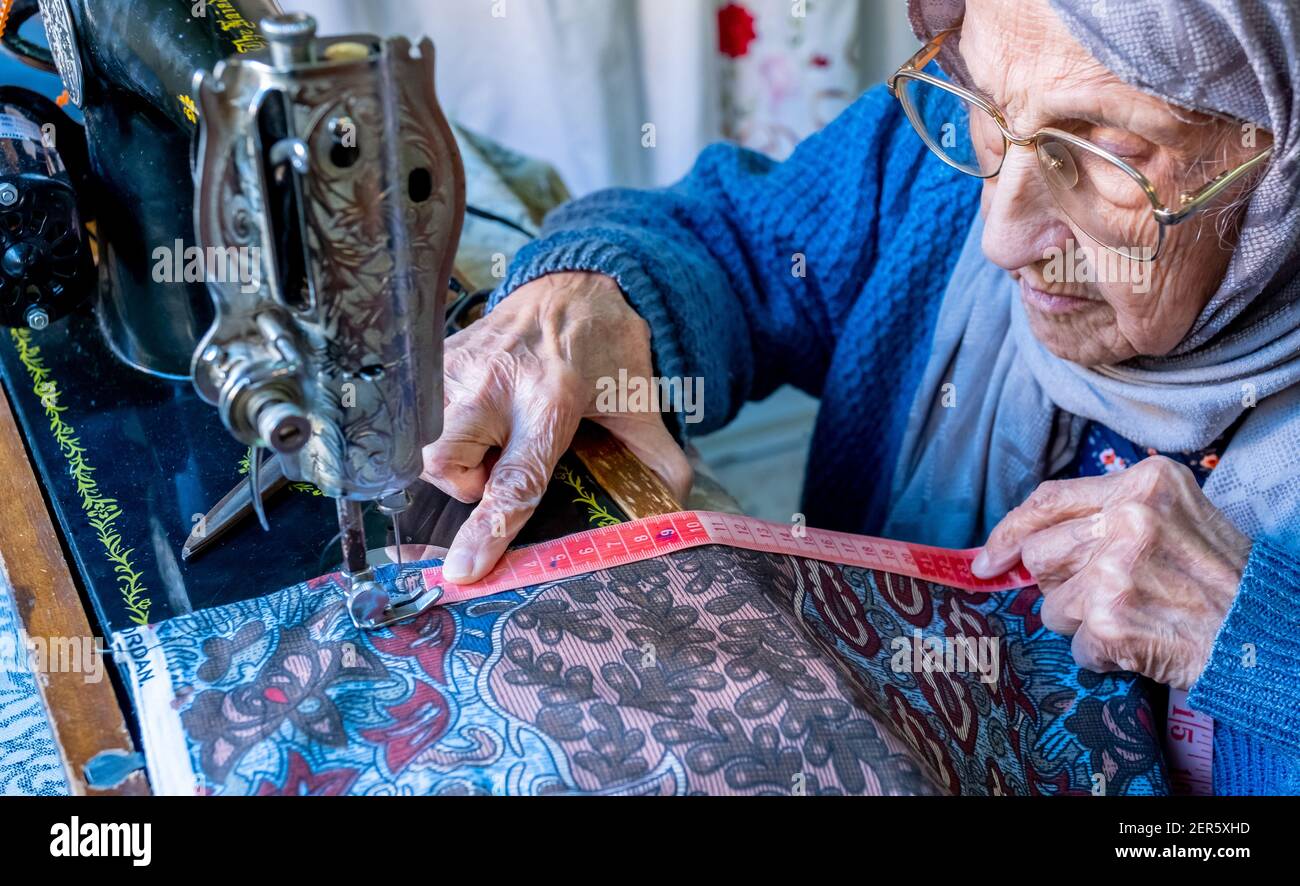 Arabic muslim woman sewing and measuring lengths with her tape Stock ...