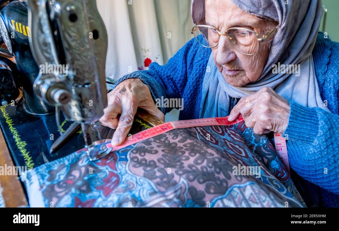 Arabic muslim woman sewing and measuring lengths with her tape Stock ...