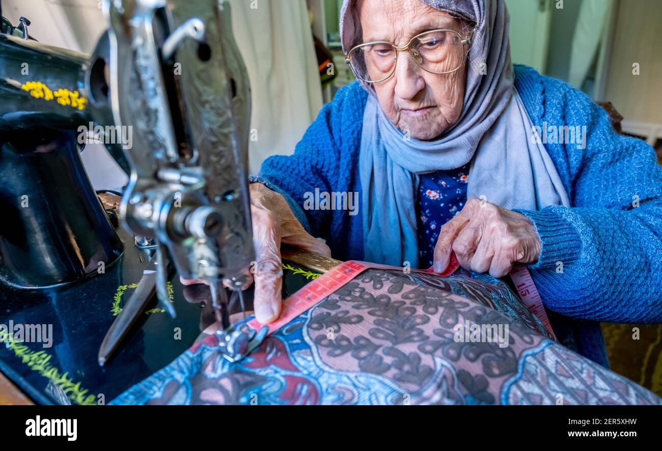 Arabic muslim woman sewing and measuring lengths with her tape Stock ...