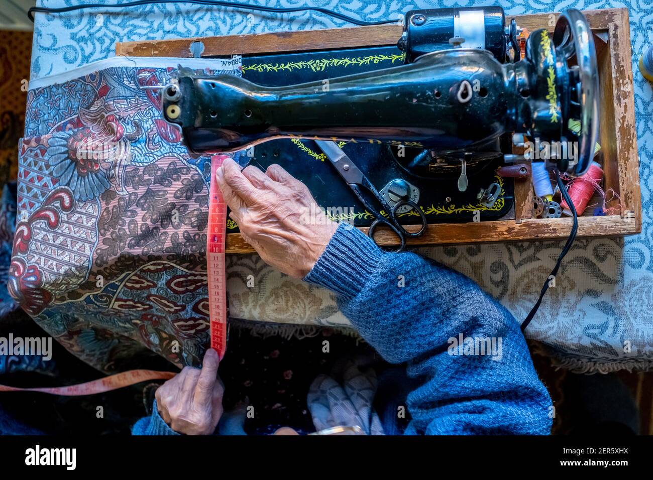 Arabic muslim woman sewing and measuring lengths with her tape Stock ...