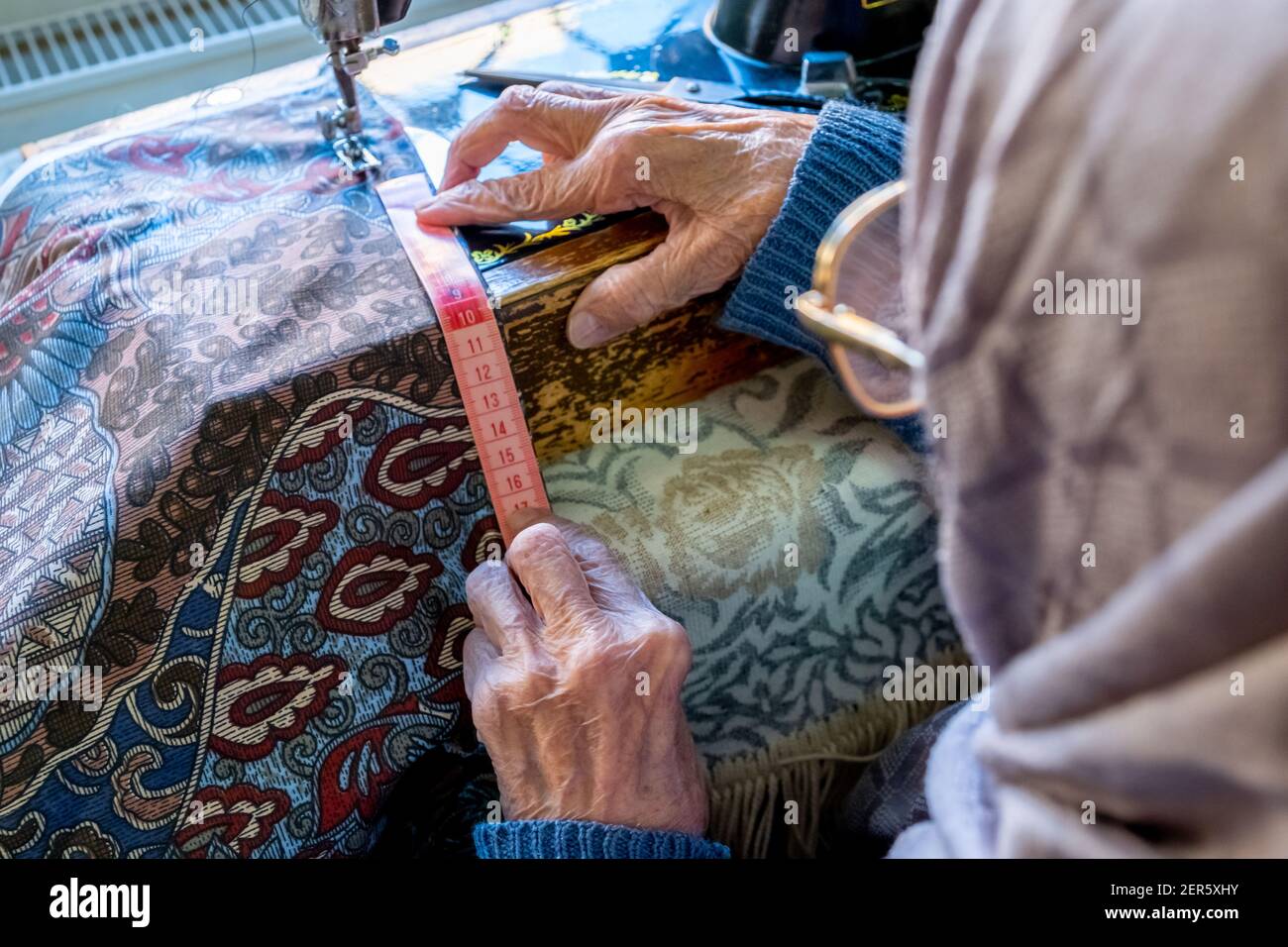 Arabic muslim woman sewing and measuring lengths with her tape Stock ...