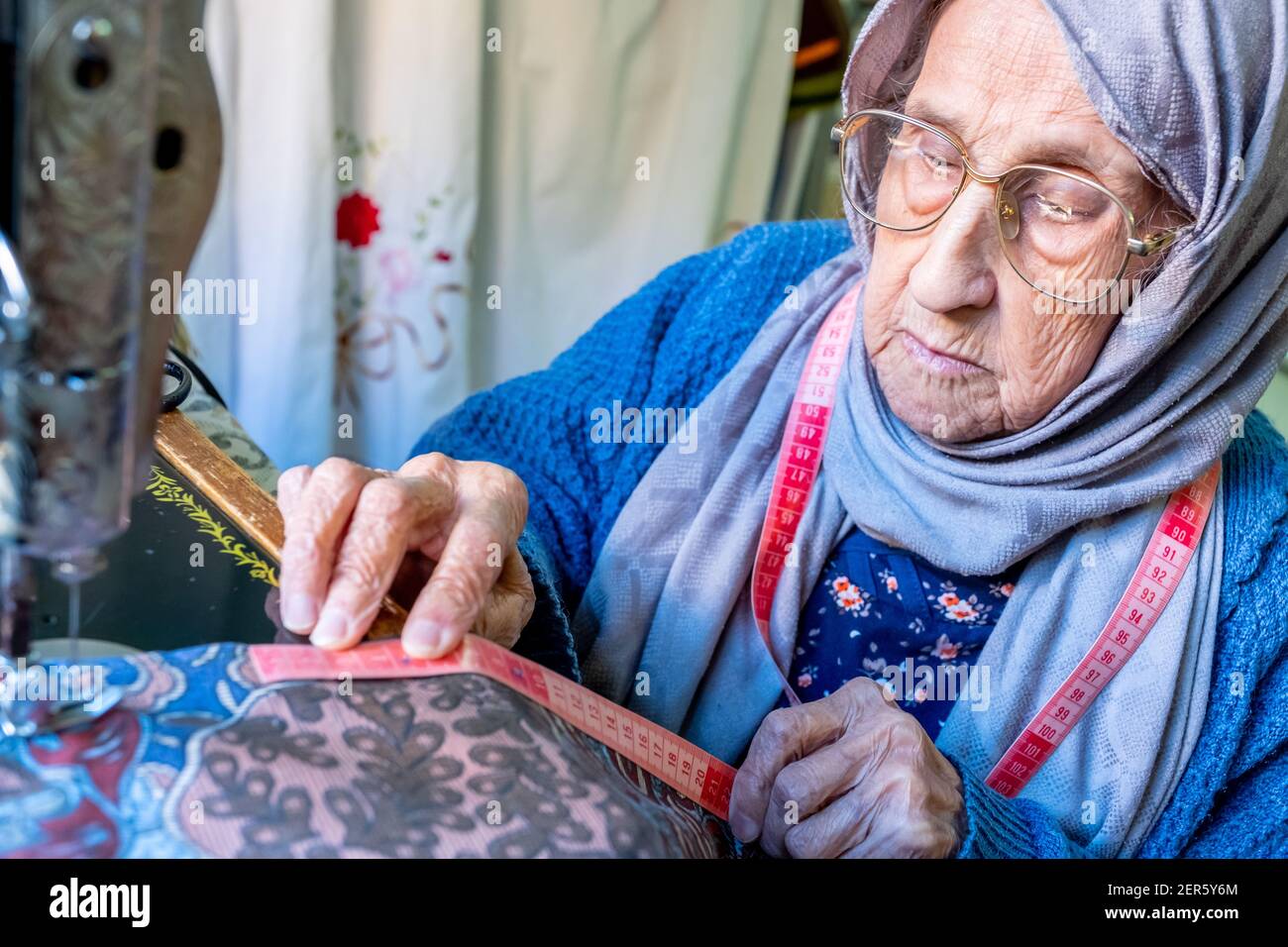 Arabic muslim woman sewing and measuring lengths with her tape Stock ...