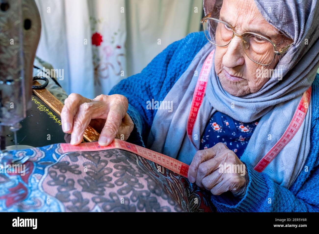 Arabic muslim woman sewing and measuring lengths with her tape Stock ...