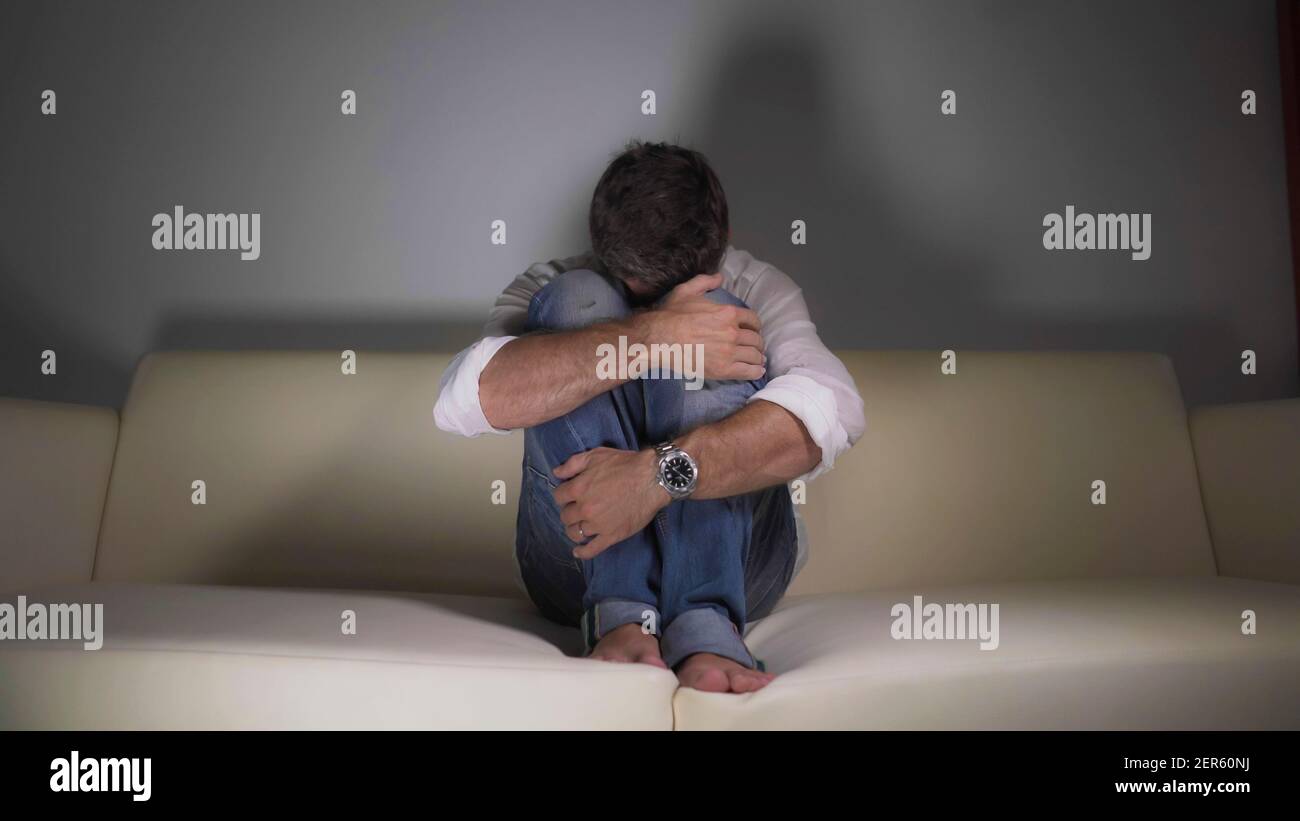 man at home in despair - young depressed and desperate man crying on ...