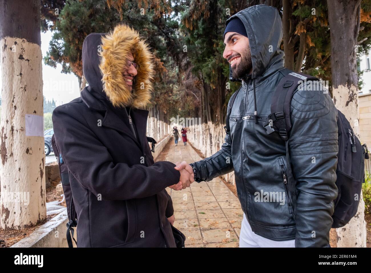 Happy muslim friends shaking hands at university Stock Photo - Alamy