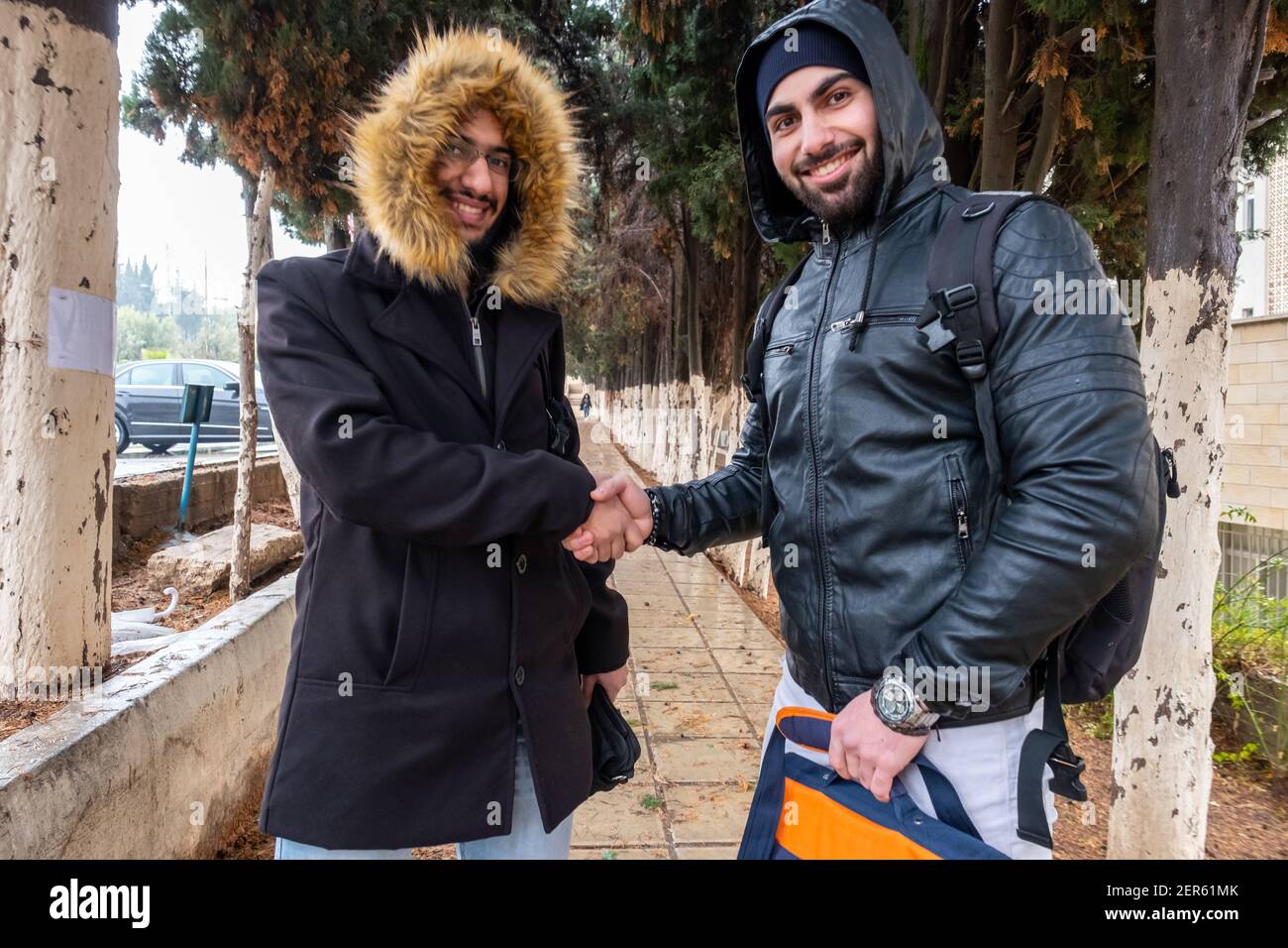 Happy muslim friends shaking hands at university Stock Photo - Alamy