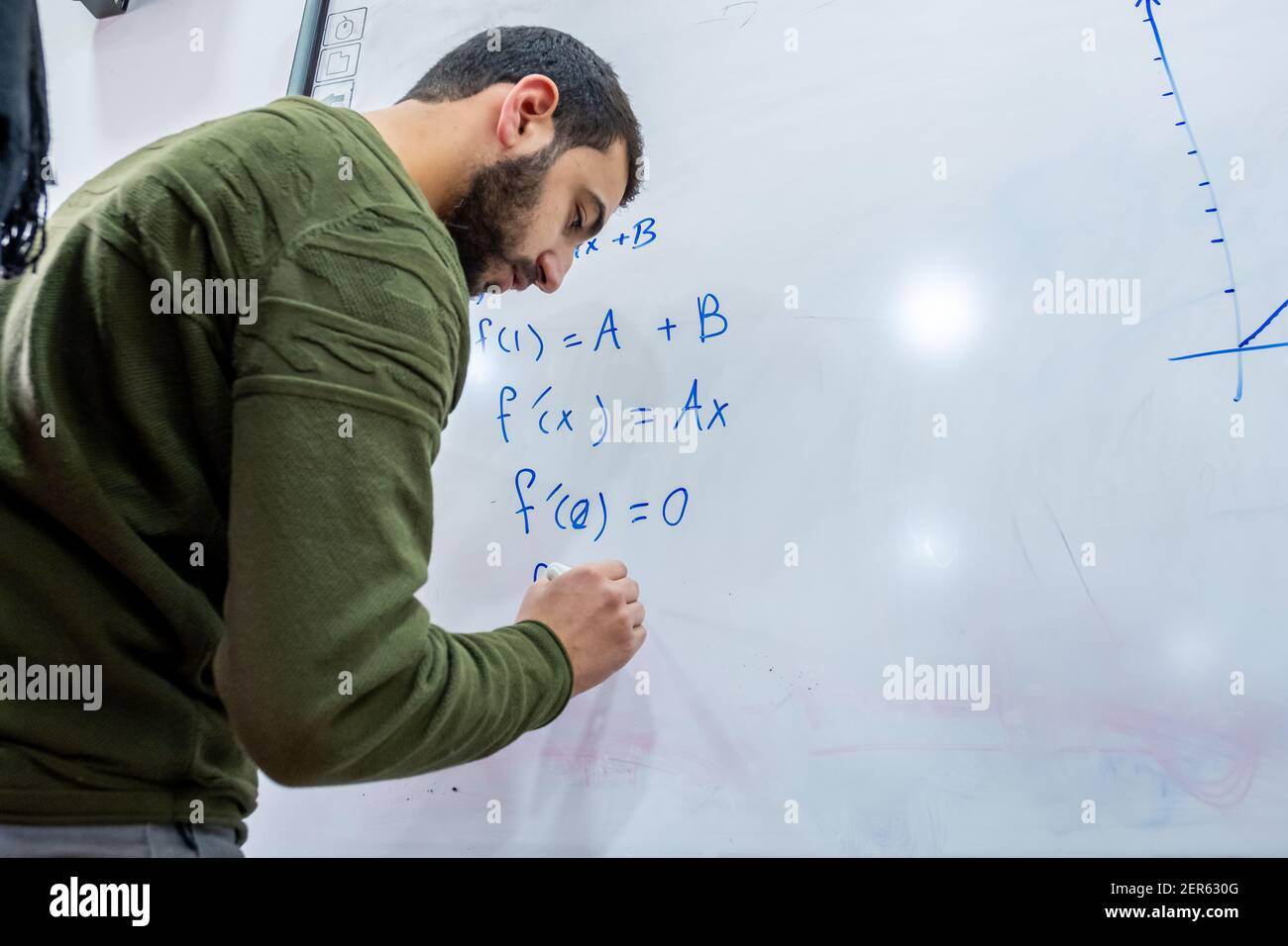 Teacher at university teaching his students how to solve mathmetics ...