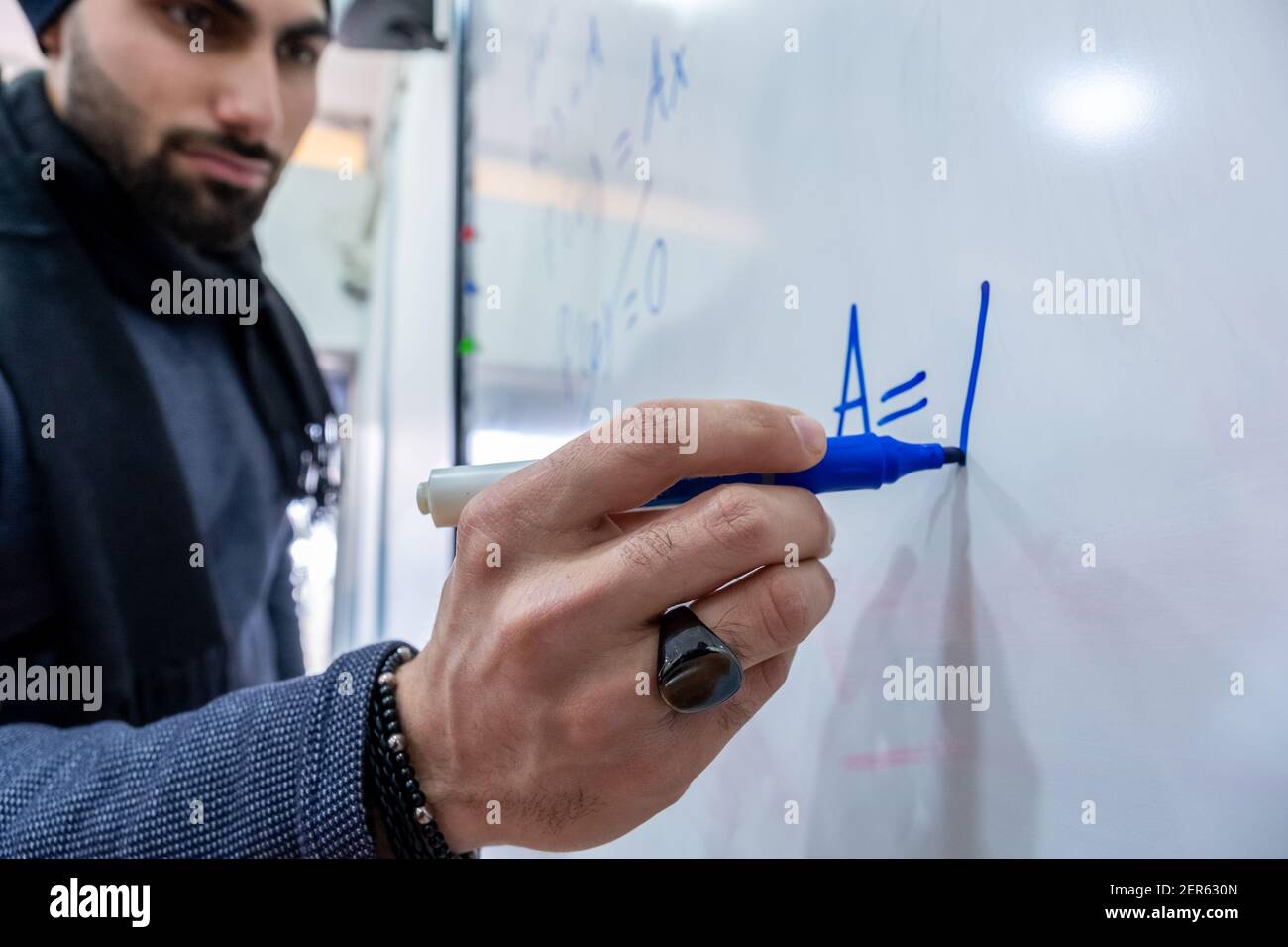 Teacher at university teaching his students how to solve mathmetics ...