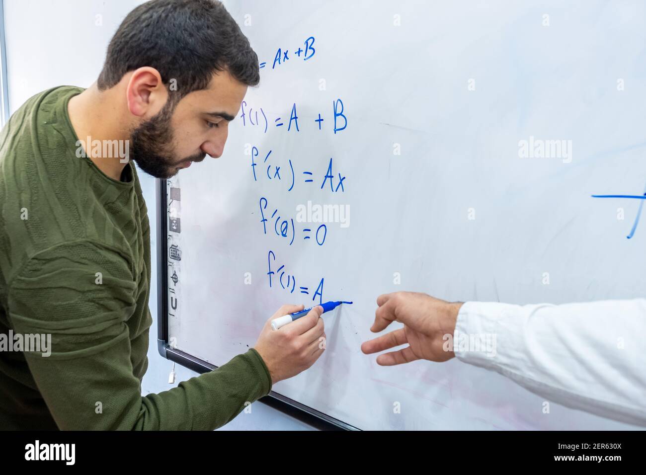 Teacher at university teaching his students how to solve mathmetics ...