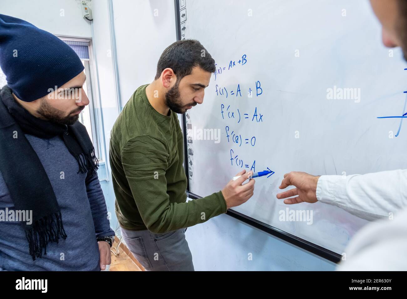 Teacher at university teaching his students how to solve mathmetics ...