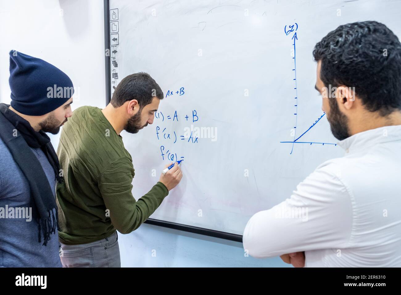 Teacher at university teaching his students how to solve mathmetics ...
