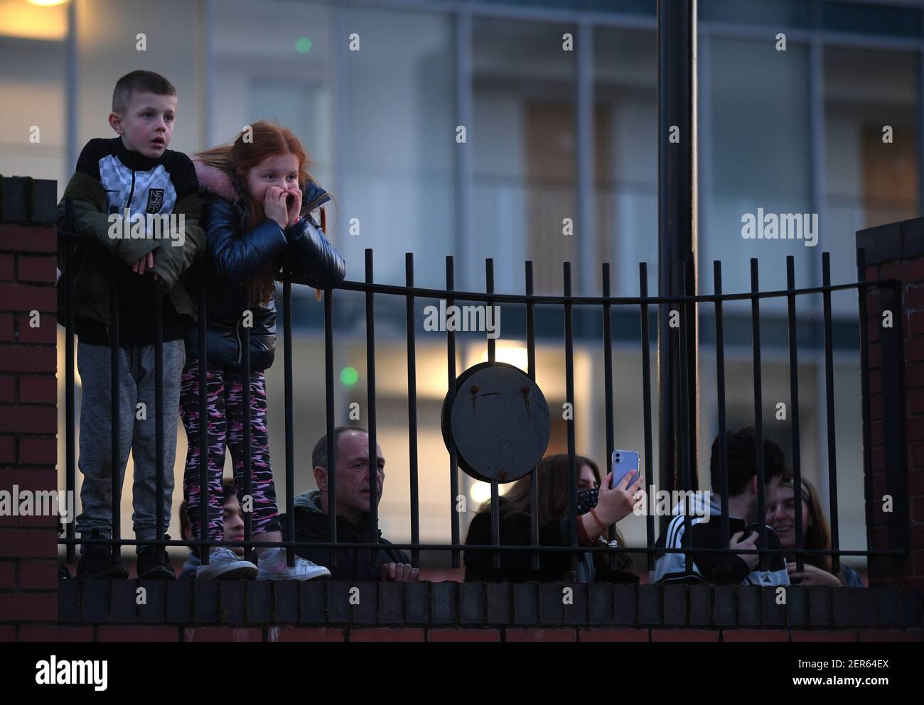 Fans watch the Liverpool team bus arriving at the stadium before the ...
