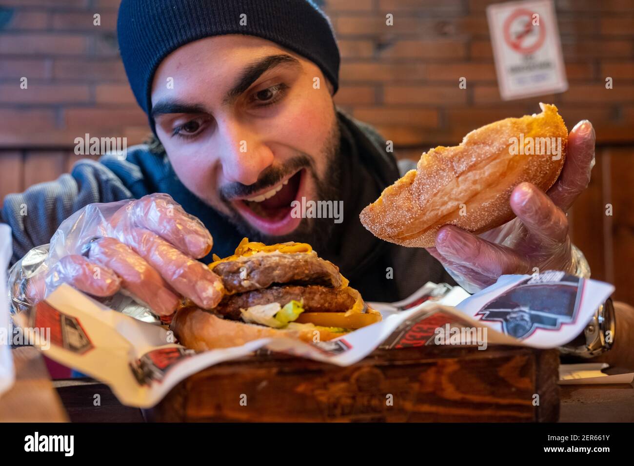 Arabic man at restaurant eating burger Stock Photo - Alamy