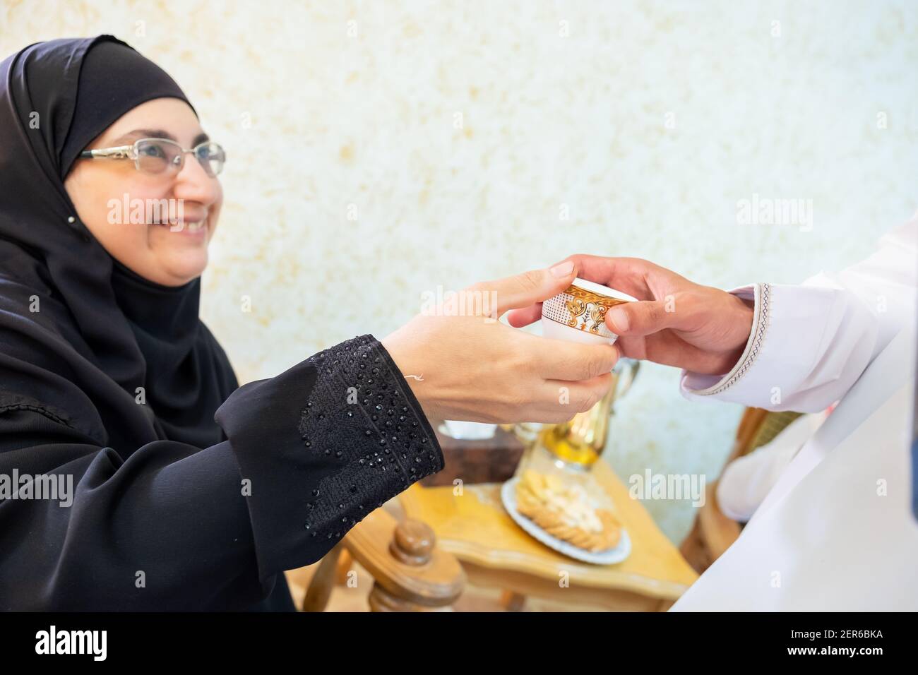 Muslim woman being served some arabic coffee while visiting her friend ...