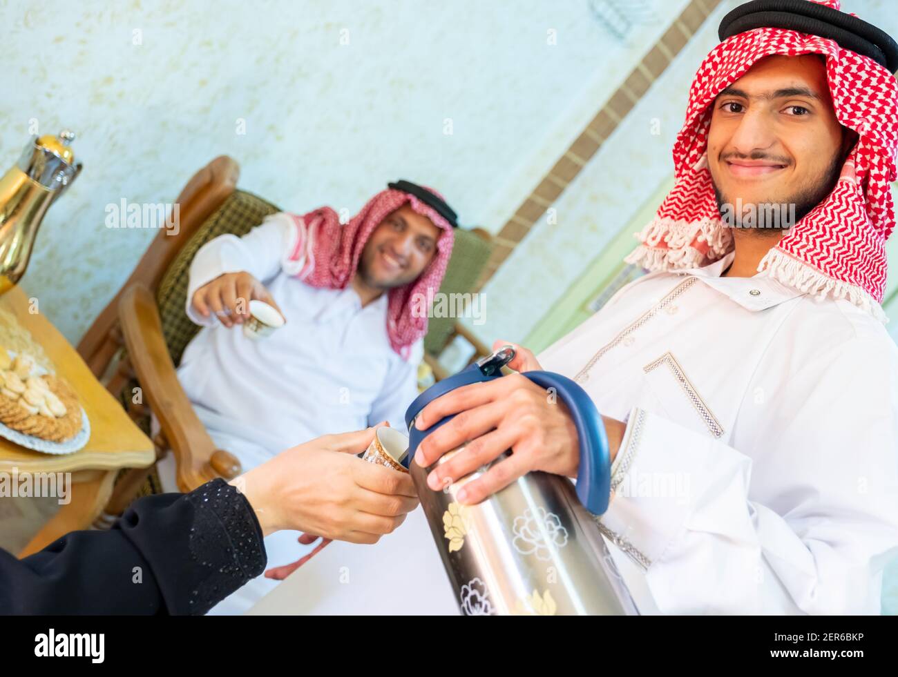 Muslim woman being served some arabic coffee while visiting her friend ...
