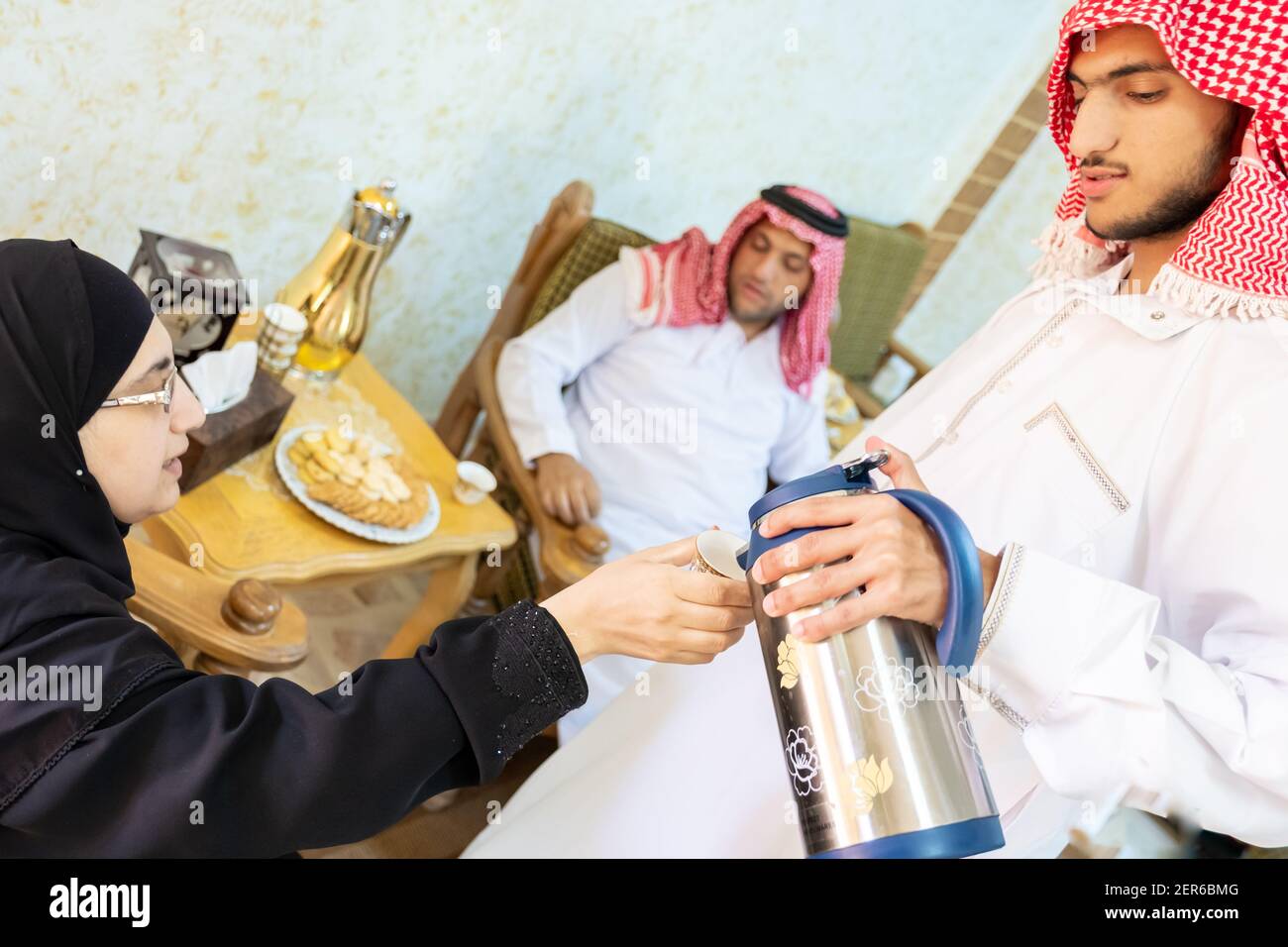 Muslim woman being served some arabic coffee while visiting her friend ...