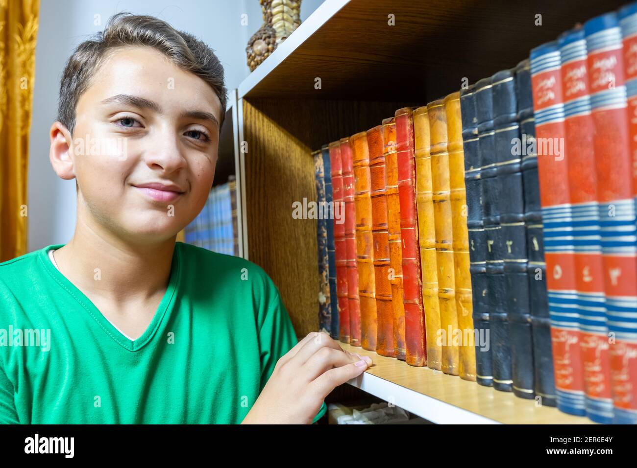 Muslim arabic boy reading book in library Stock Photo - Alamy