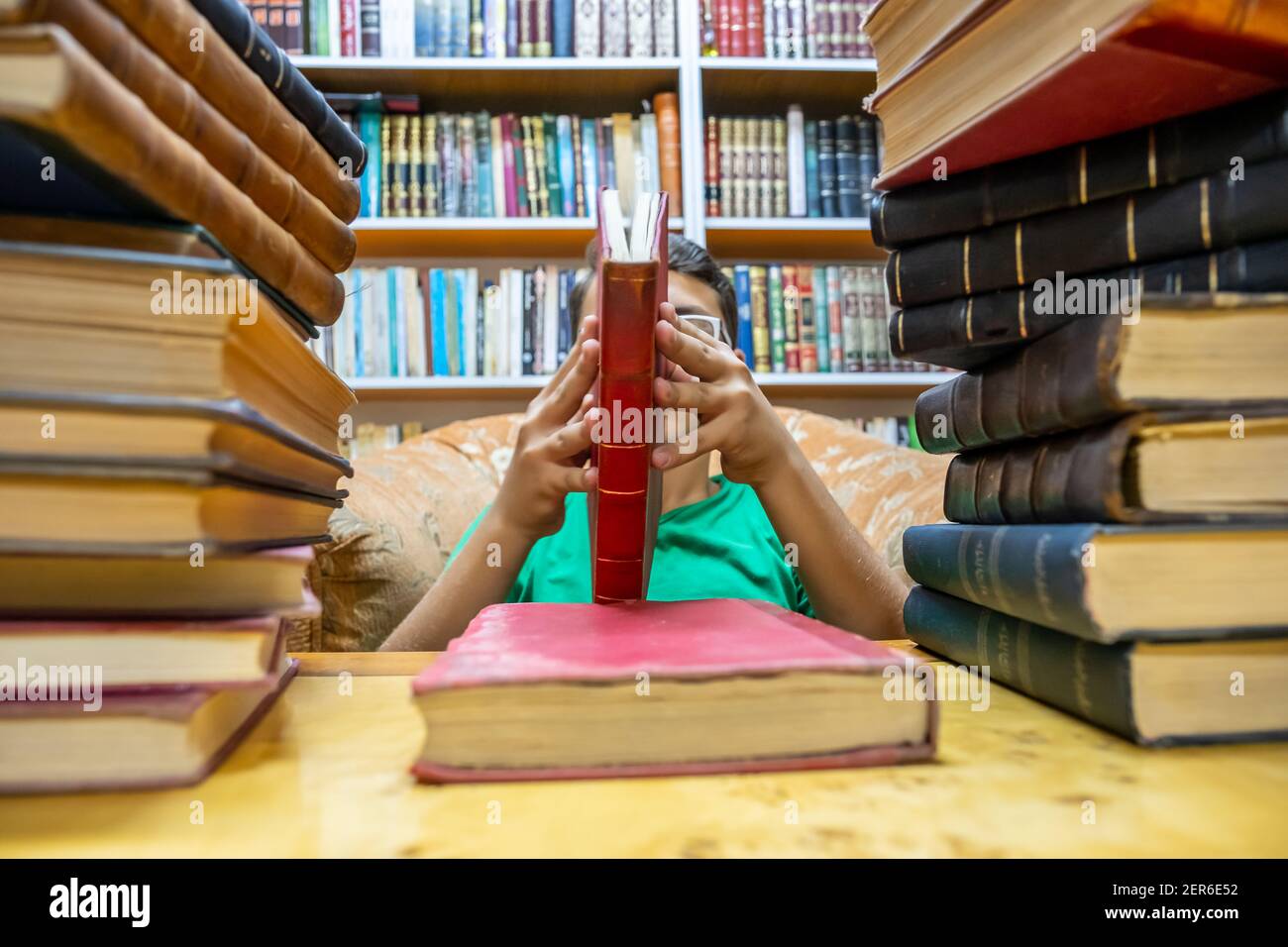 Muslim arabic boy reading book in library Stock Photo - Alamy