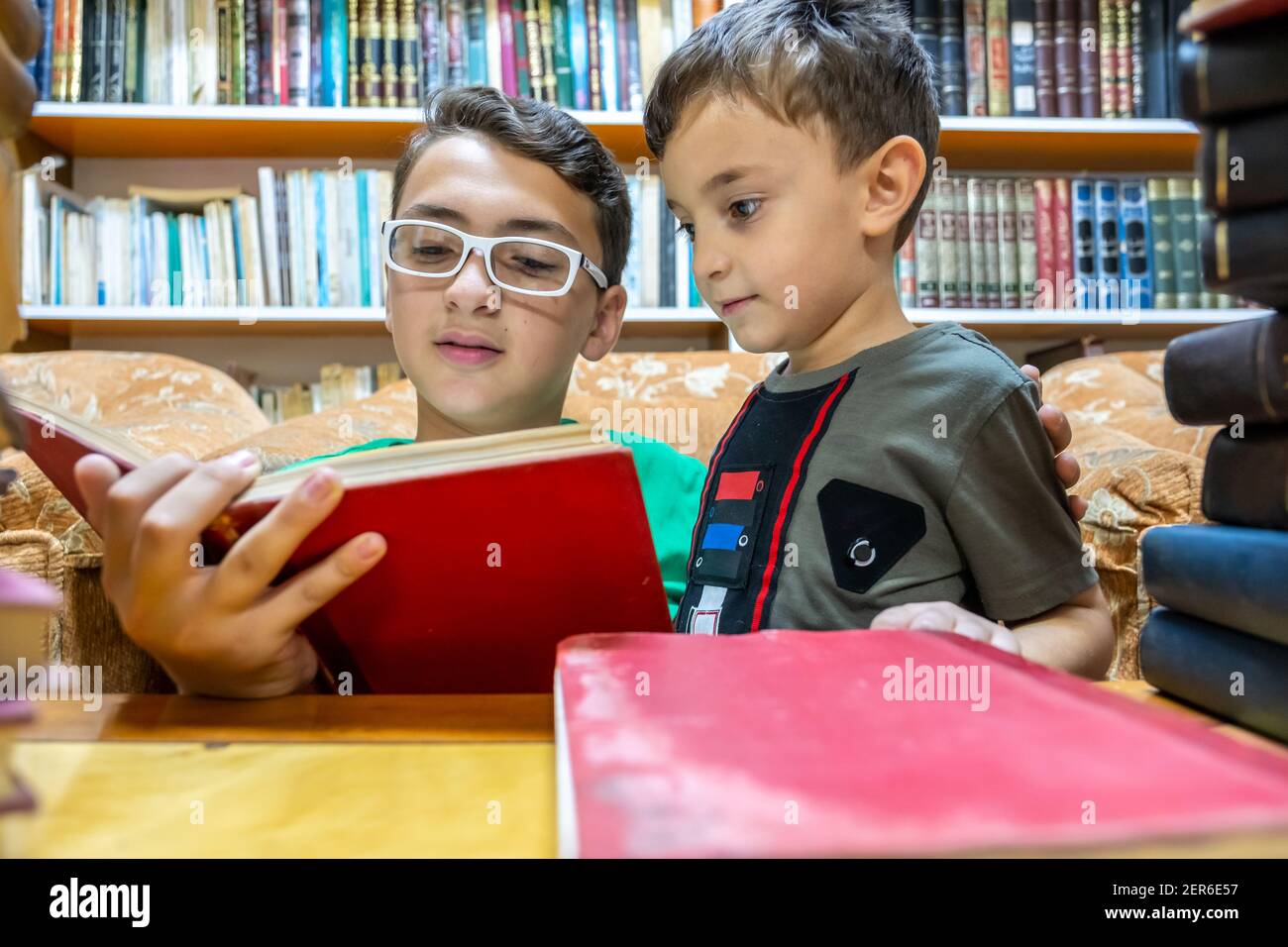 Muslim arabic boy reading book in library Stock Photo - Alamy