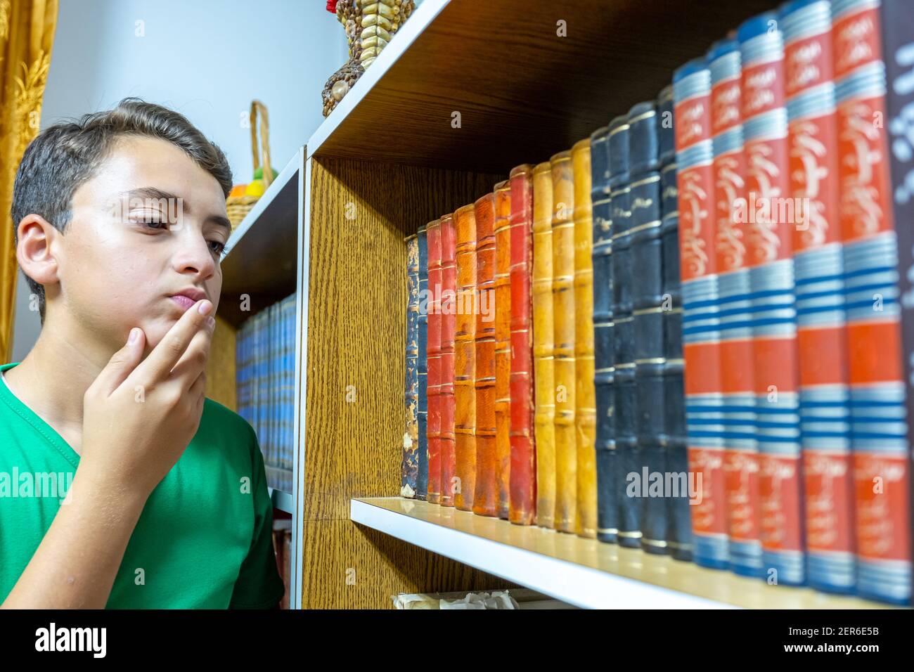 Muslim arabic boy reading book in library Stock Photo - Alamy