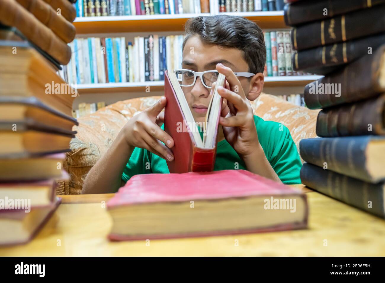 Muslim arabic boy reading book in library Stock Photo - Alamy