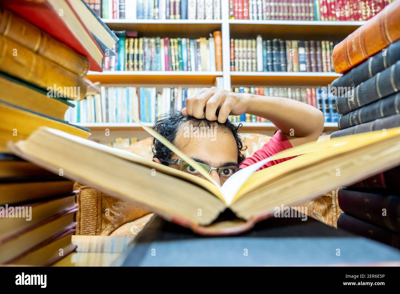 Muslim arabic boy reading book in library Stock Photo - Alamy