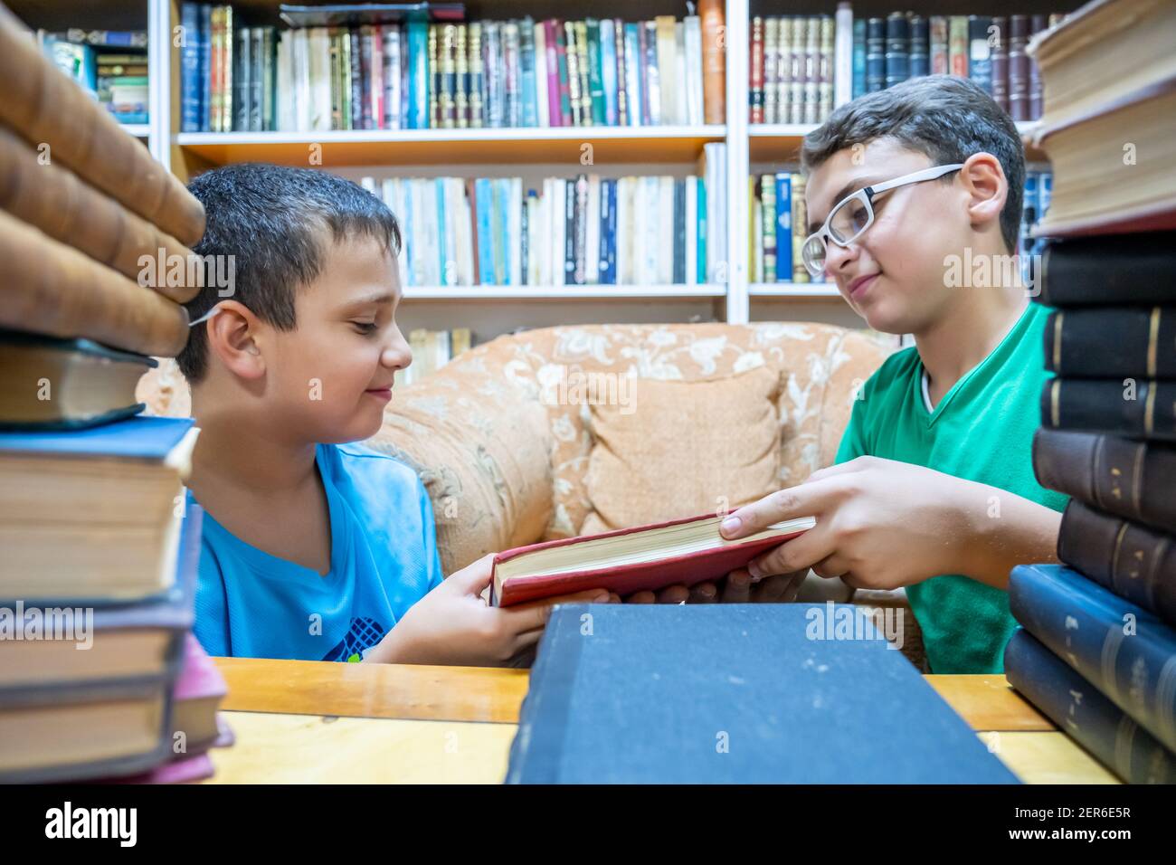 Muslim arabic boy reading book in library Stock Photo - Alamy