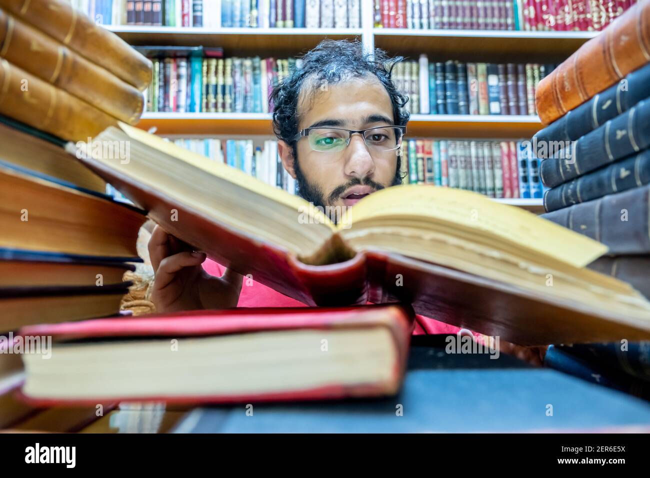 Muslim arabic boy reading book in library Stock Photo - Alamy