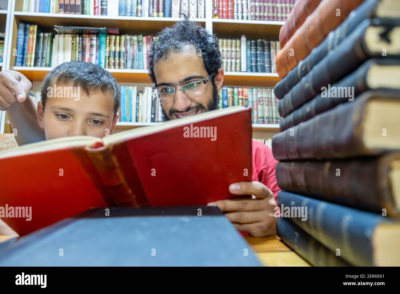 Muslim arabic boy reading book in library Stock Photo - Alamy