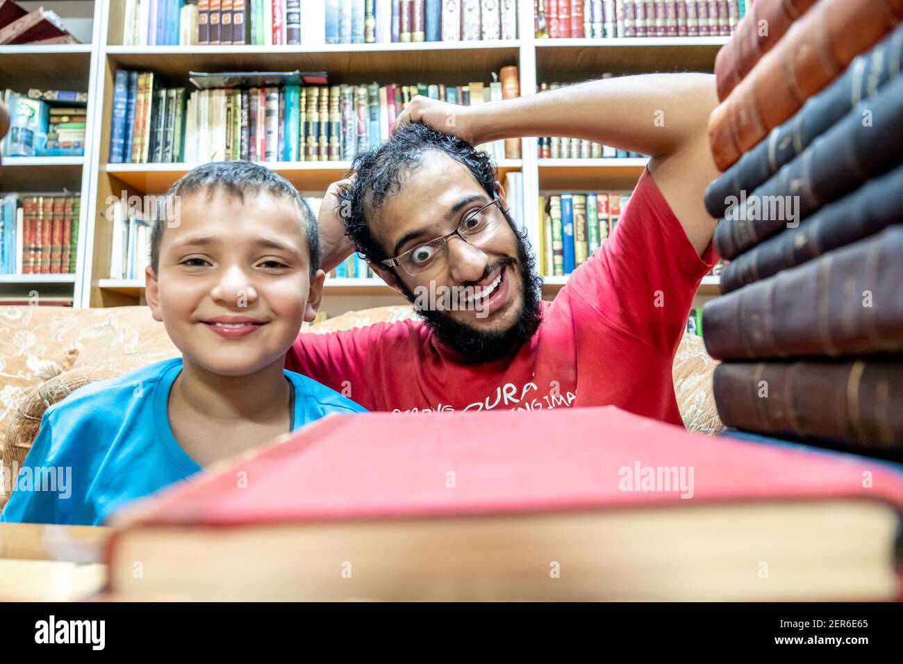 Muslim arabic boy reading book in library Stock Photo - Alamy