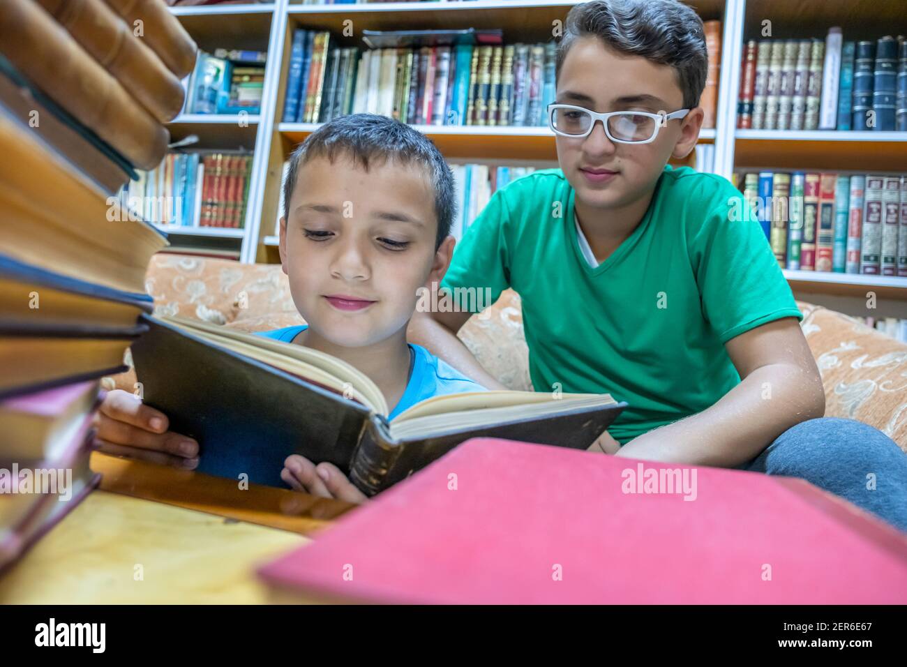 Muslim arabic boy reading book in library Stock Photo - Alamy