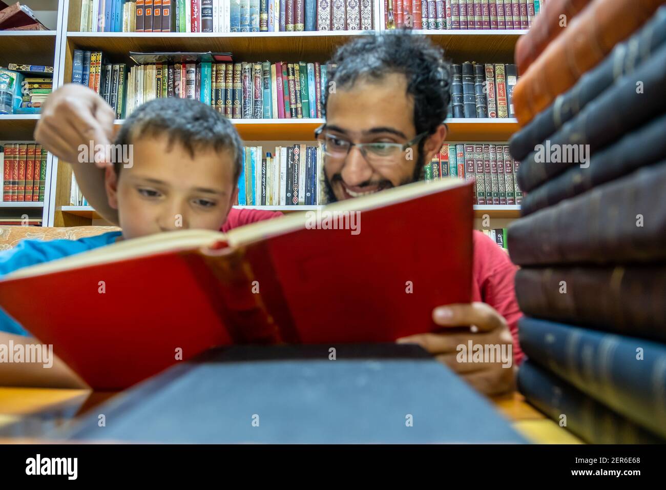Muslim arabic boy reading book in library Stock Photo - Alamy