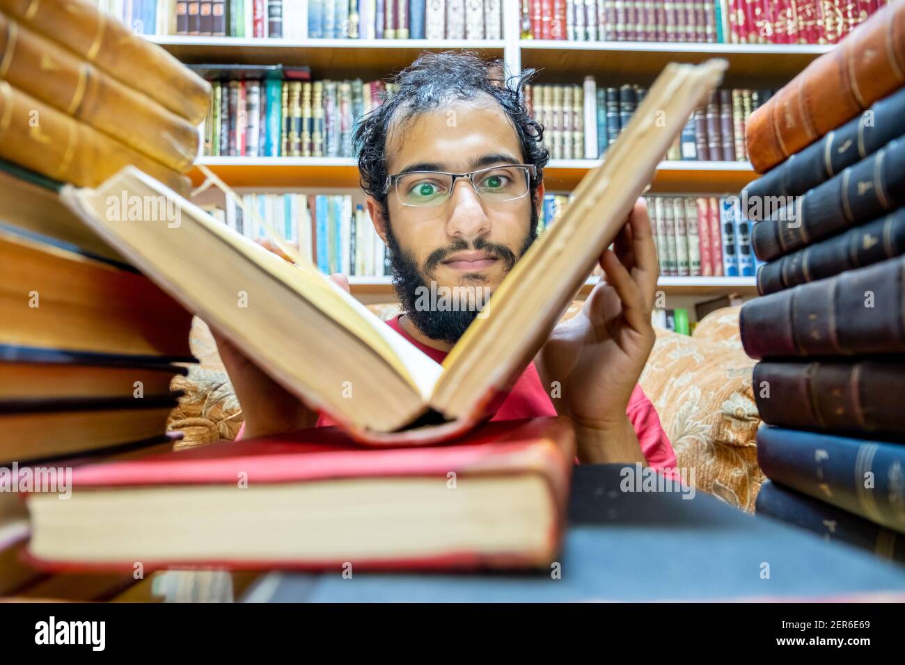 Muslim arabic boy reading book in library Stock Photo - Alamy