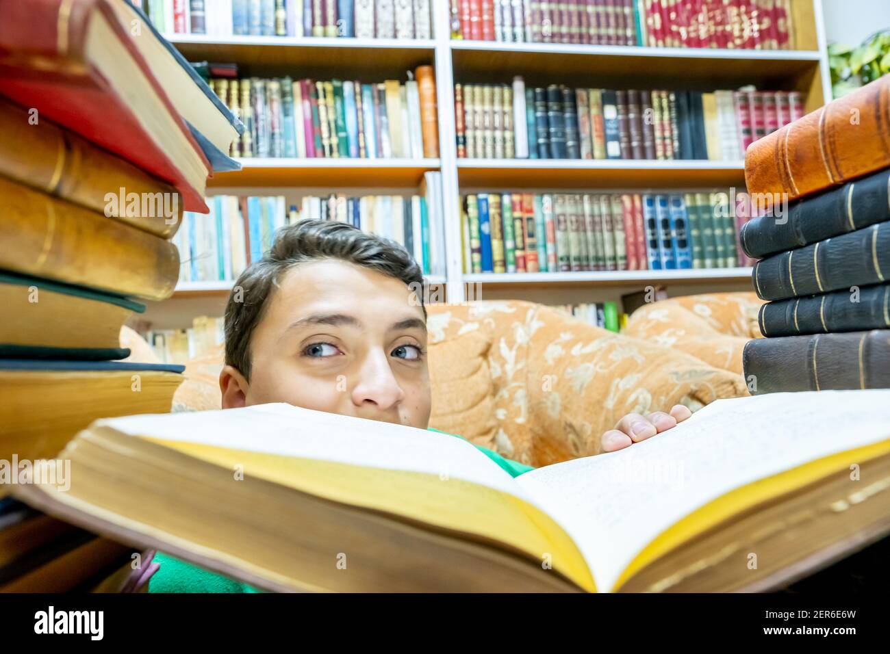 Muslim arabic boy reading book in library Stock Photo - Alamy