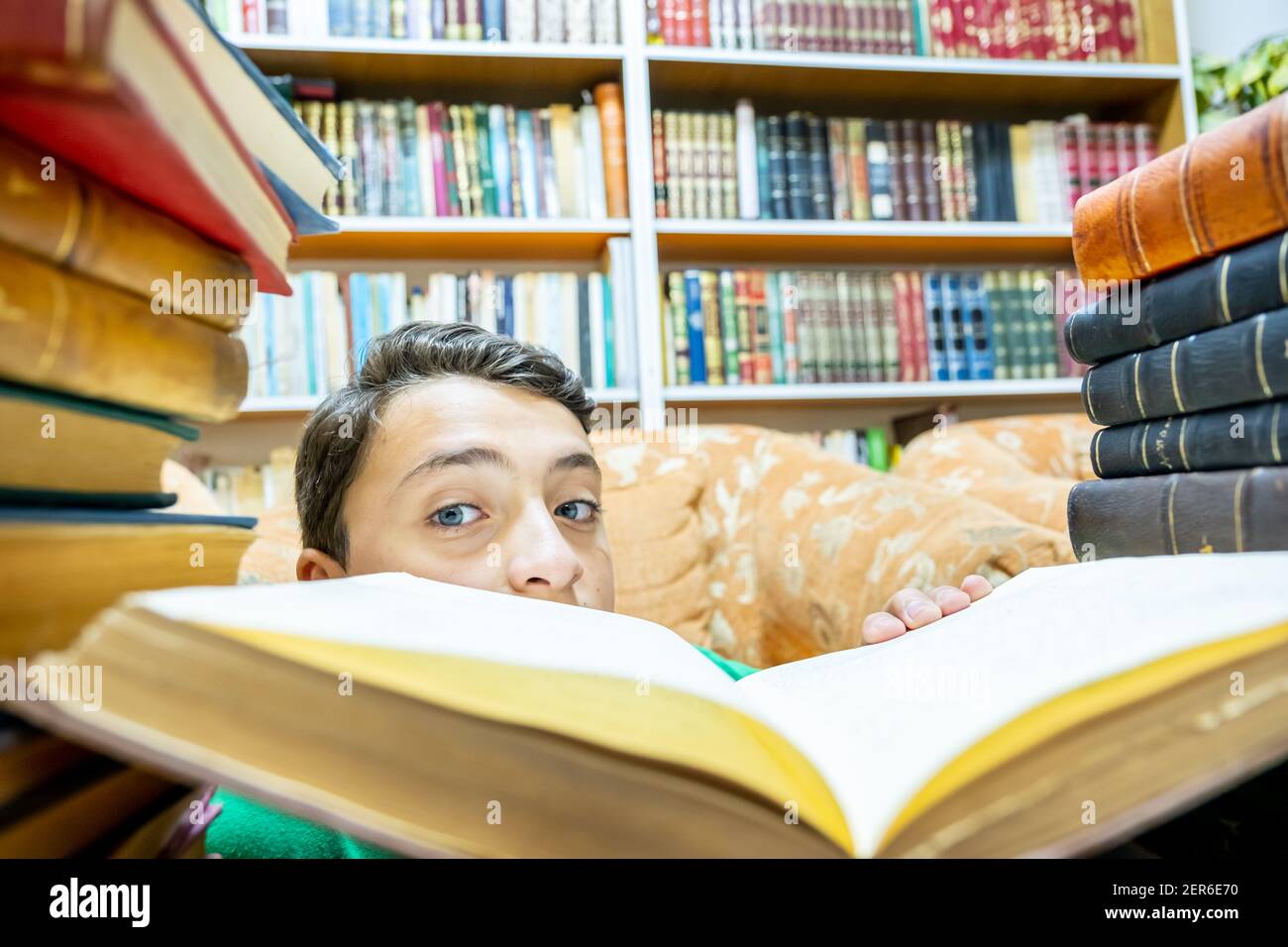 Muslim arabic boy reading book in library Stock Photo - Alamy