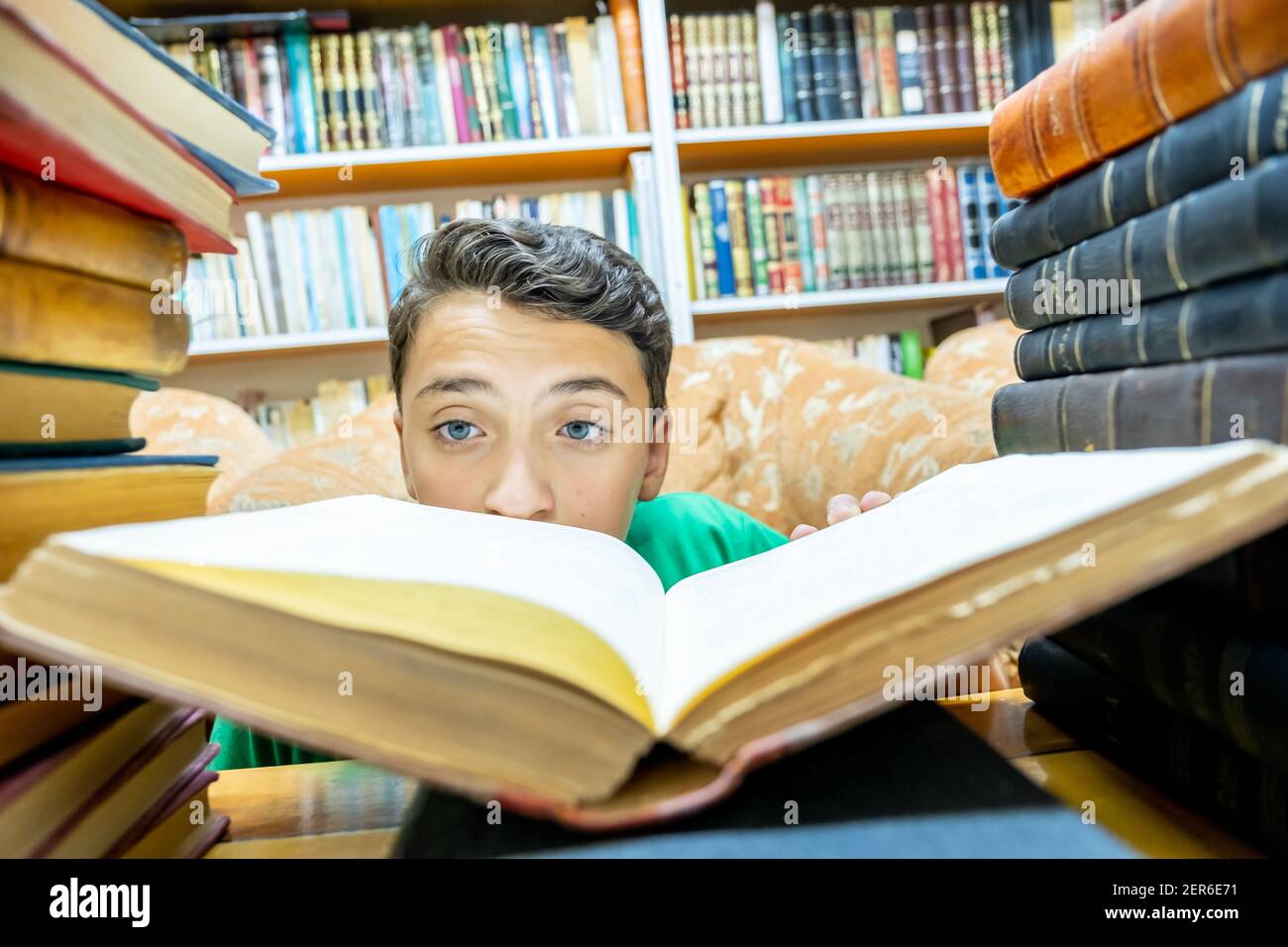Muslim arabic boy reading book in library Stock Photo - Alamy