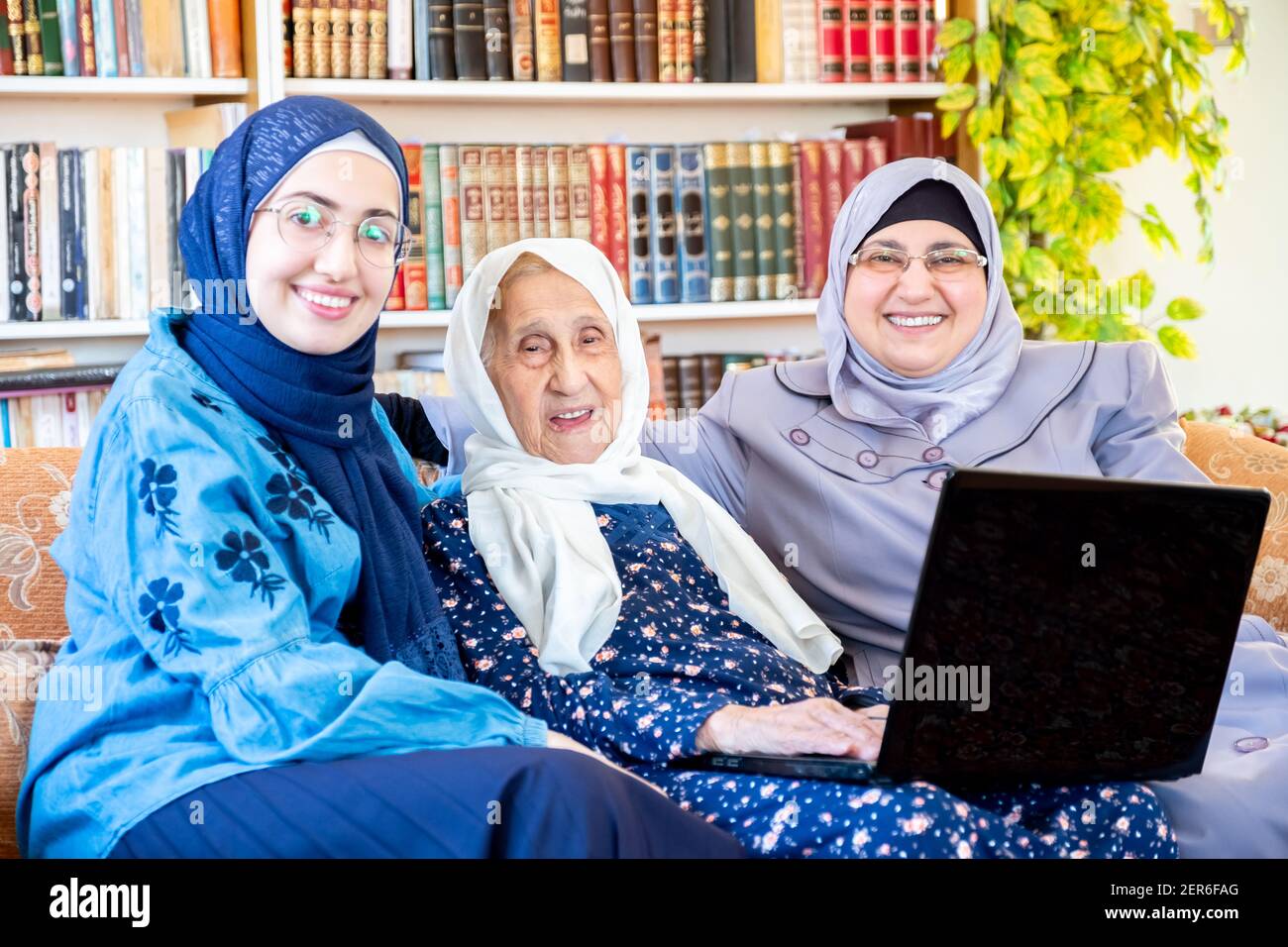 Happy Arabic Muslim grandmother and granddaughter and mother sitting ...