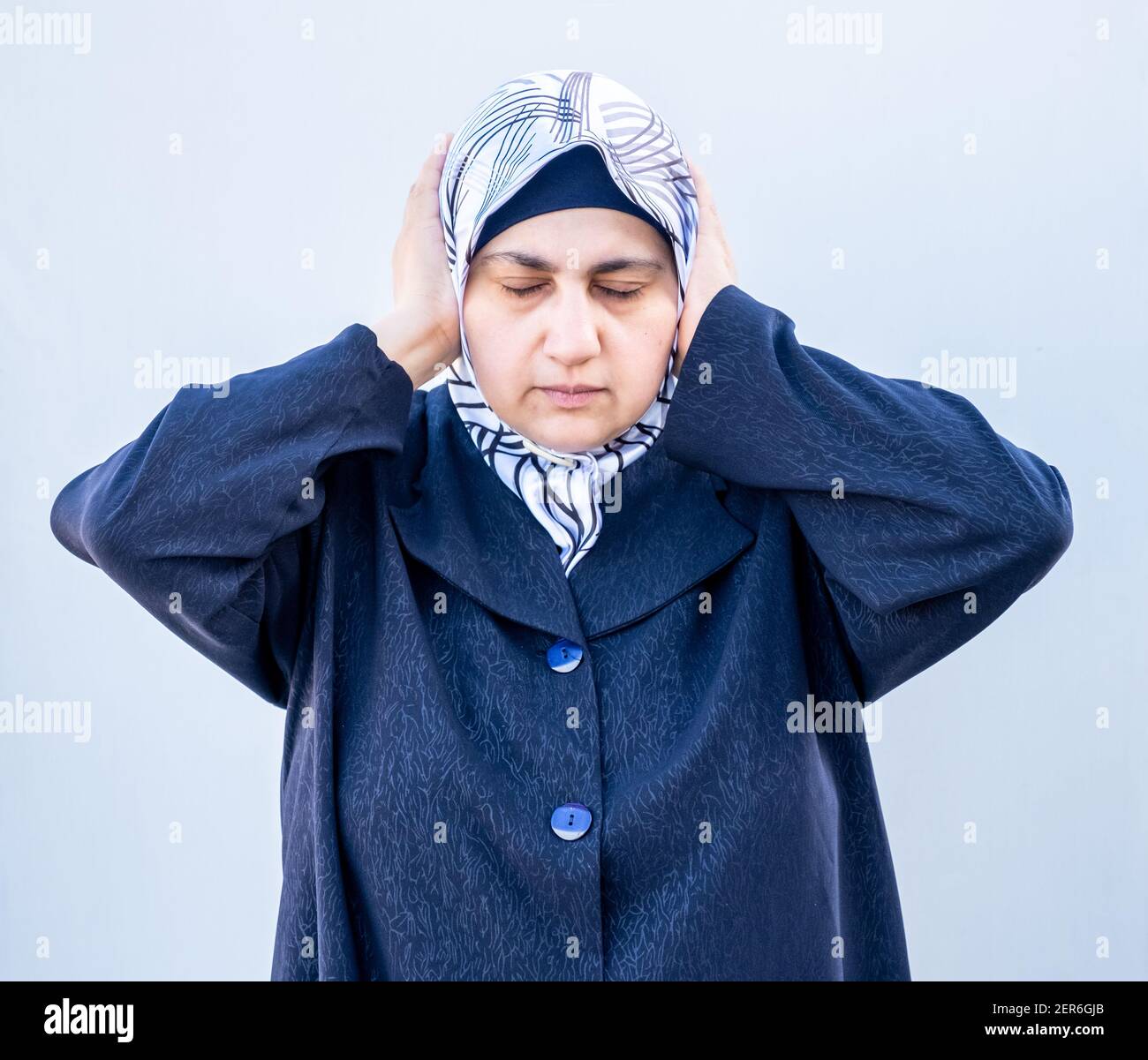 Arabic muslim woman shutting her ears from loud noise Stock Photo - Alamy