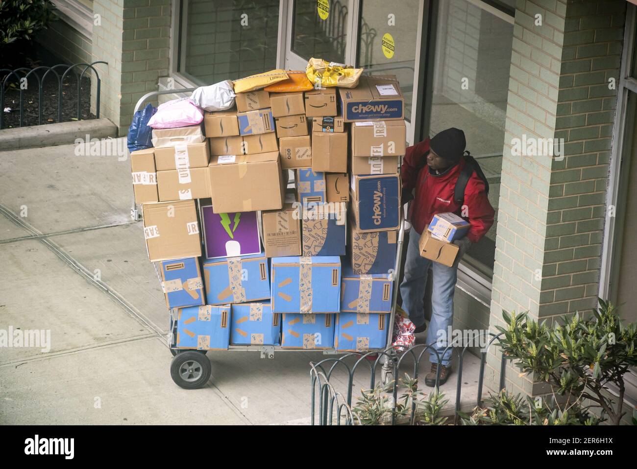 A deliveryman from Lasership with his cart laden with purchases from ...