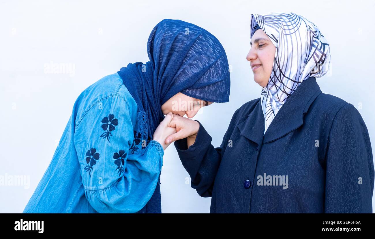Arabic muslim girl kissing her mother hands out of respect Stock Photo ...