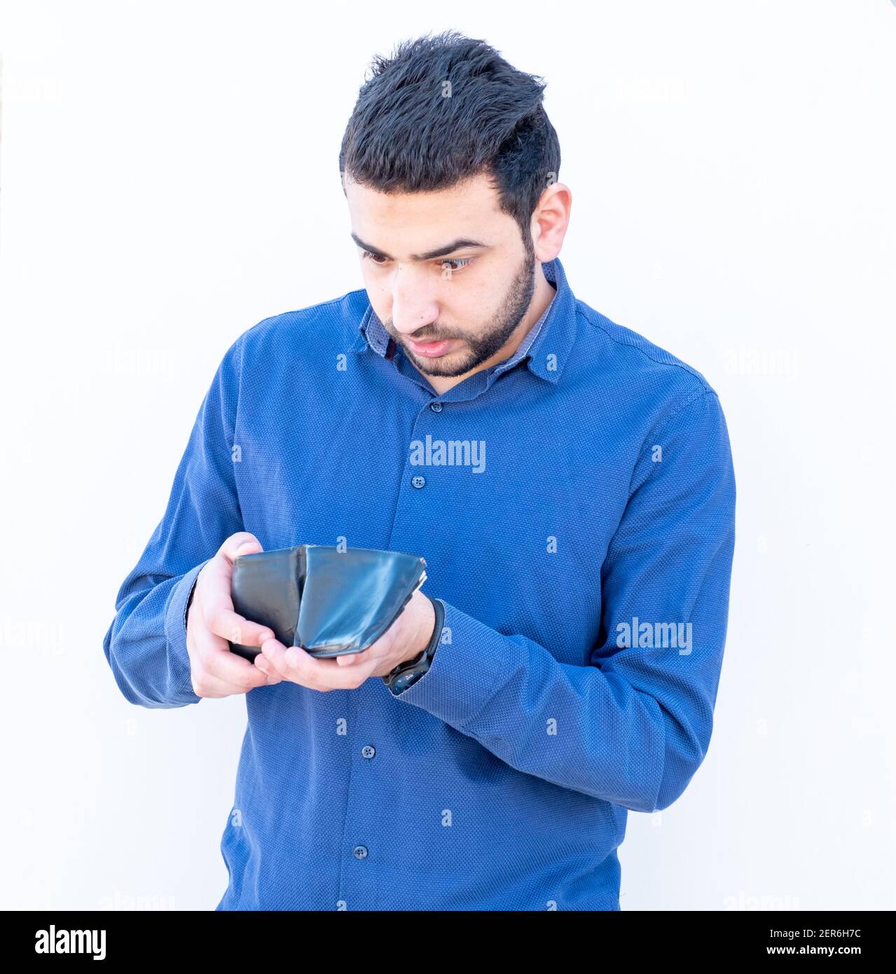Arabic holding his wallet and pocket looking for money Stock Photo - Alamy