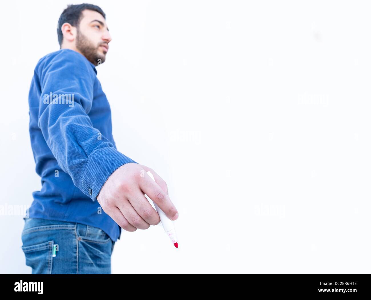 Arabic guy holding pen to write with it in a class Stock Photo - Alamy