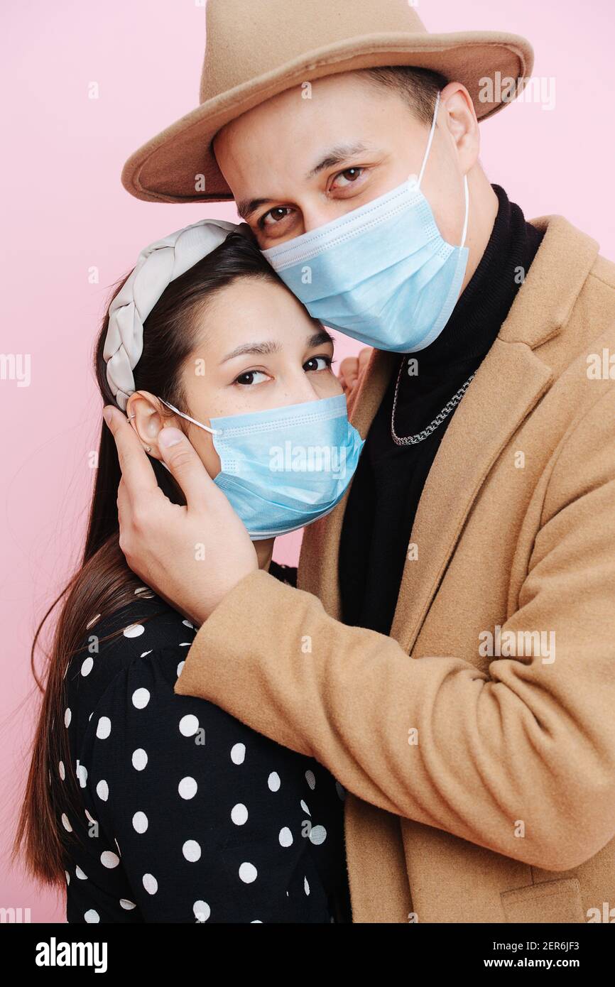 Portrait of hugging couple wearing protective medical masks. Image on ...