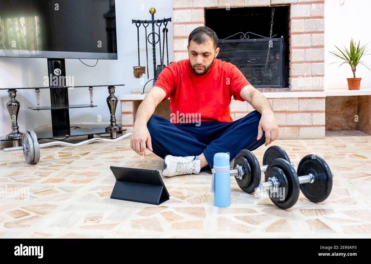 Athletic guy watching video tutorial to work out Stock Photo - Alamy