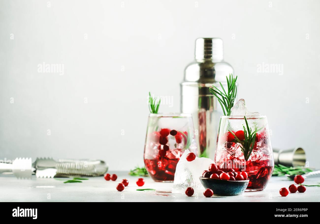 Cranberry cocktail or mocktail with ice, rosemary and red berries in ...