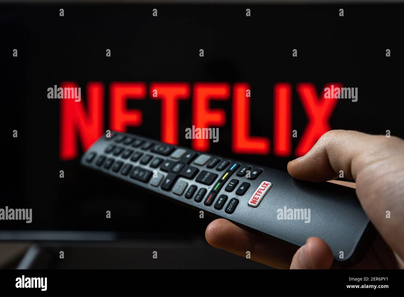 Holding TV remote controller with Netflix logo. Turning on Netflix ...