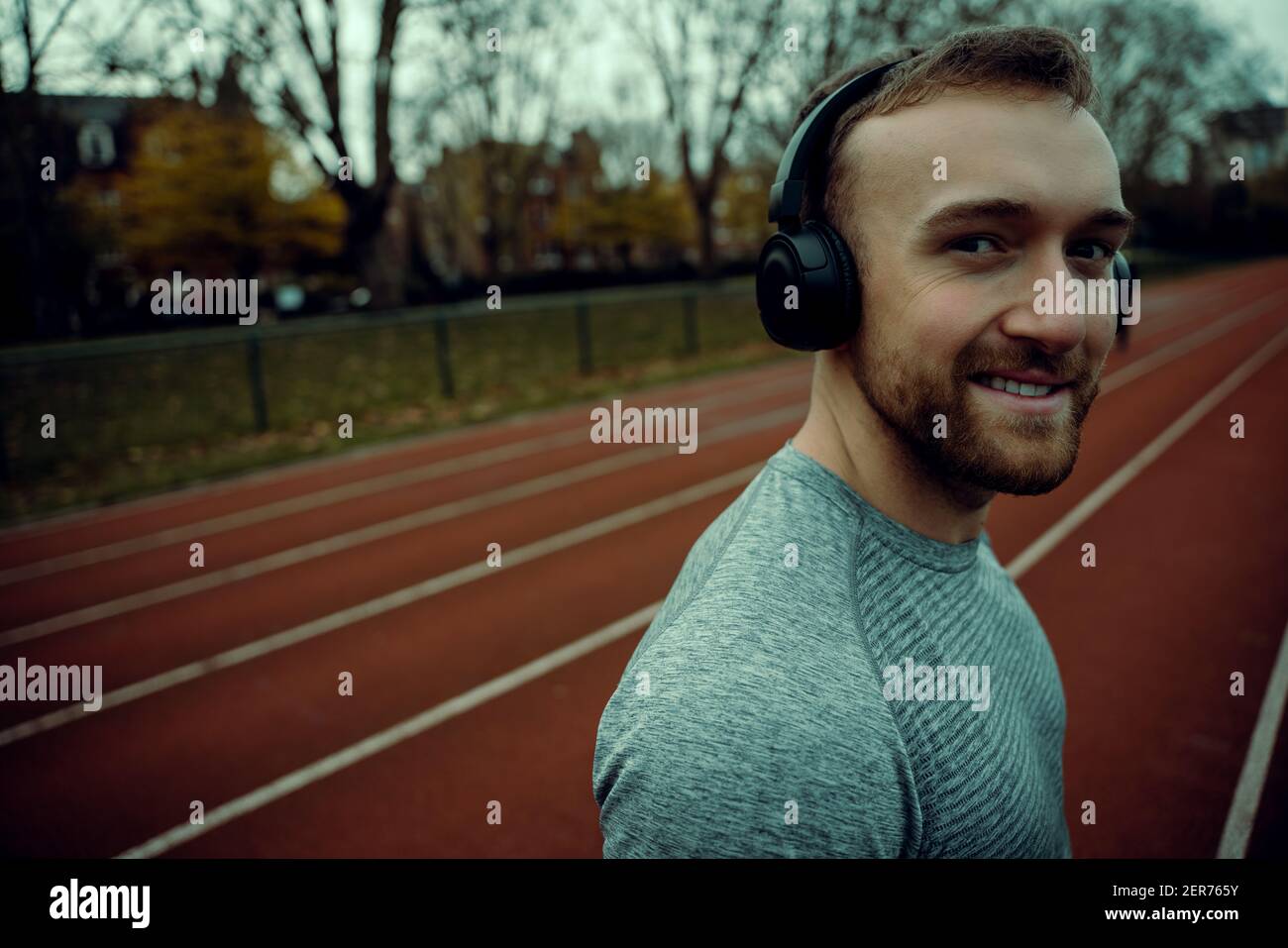 Smiling caucasian athlete listening to music with headphones Stock ...