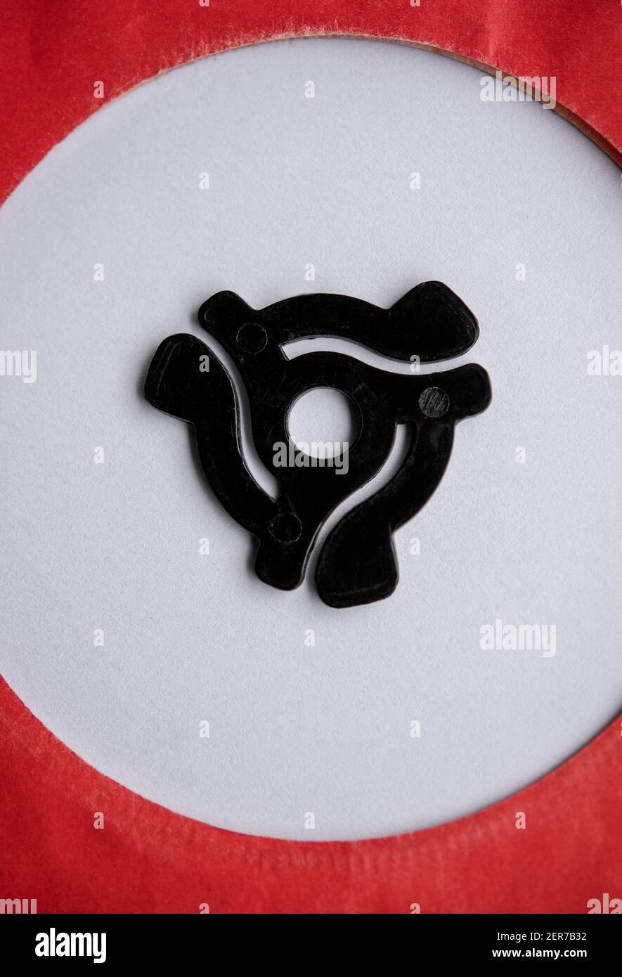Still life of a plastic centre adapter for the middle of a vinyl record ...