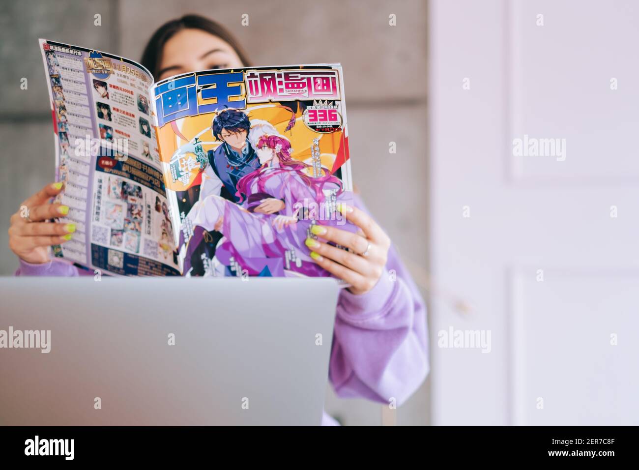 Young woman reading manga comic book at home Stock Photo - Alamy