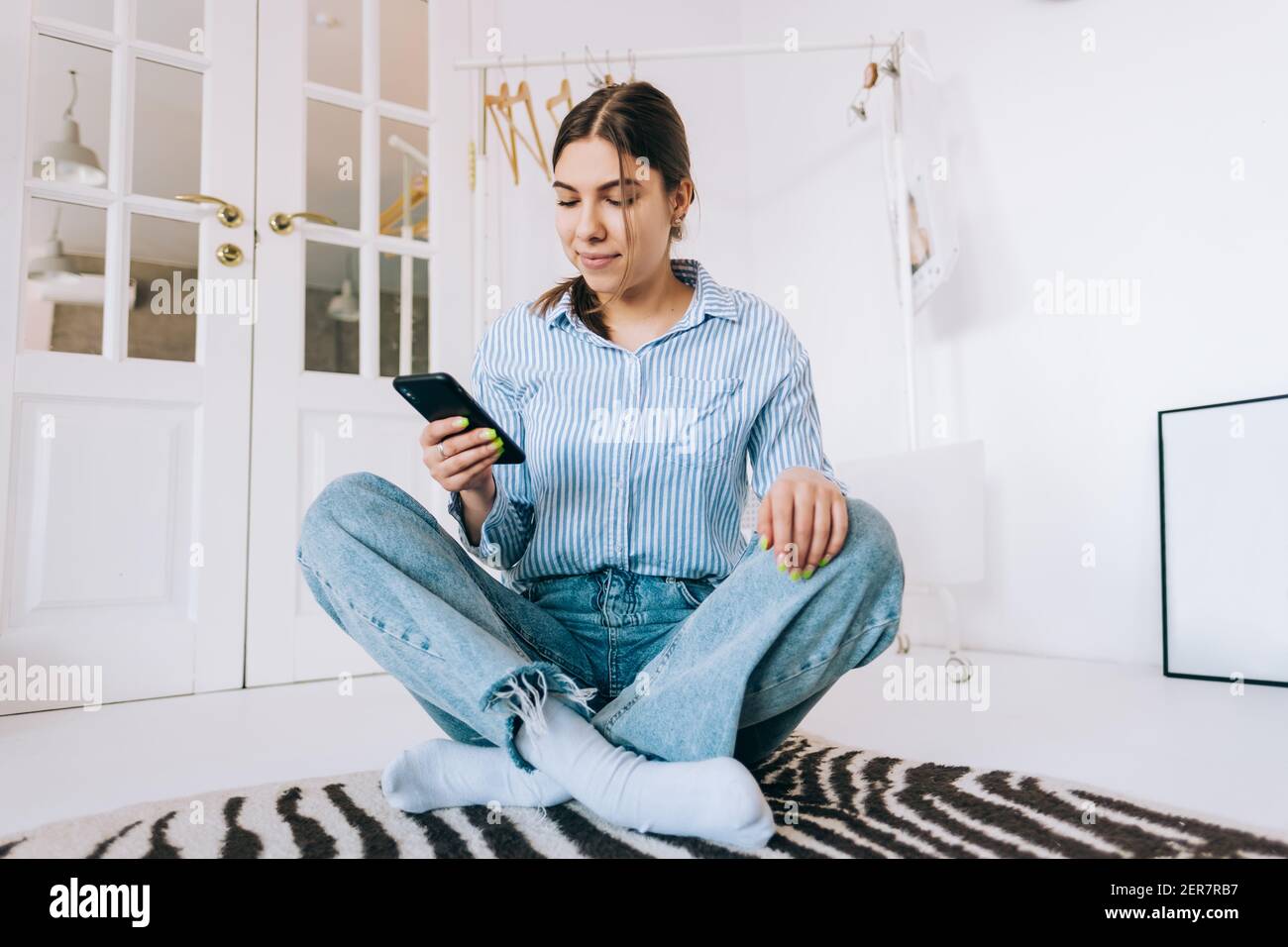 Woman sitting on floor looking at wardrobe and clothes hi-res stock ...
